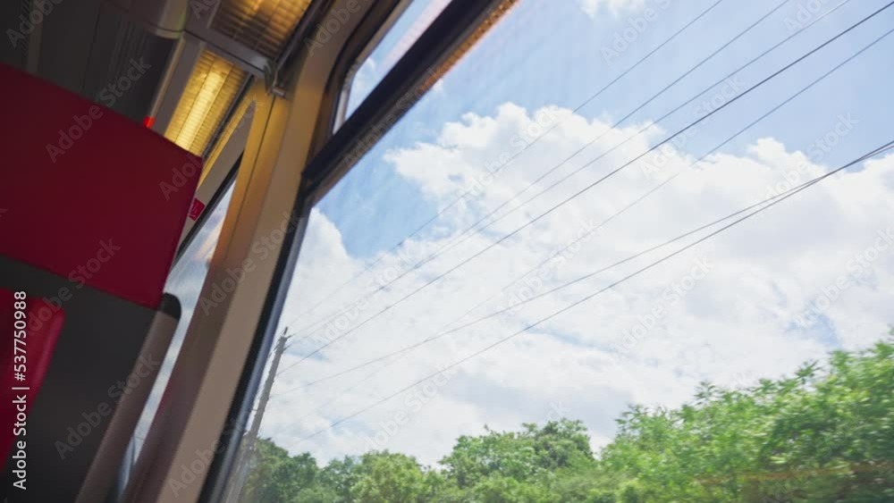 View from railway train window to the blue sky and clouds outside ...