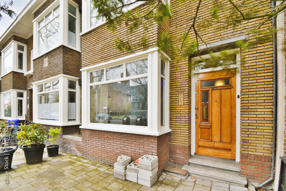 The front view of a brick building with signs, pavement and wooden ...