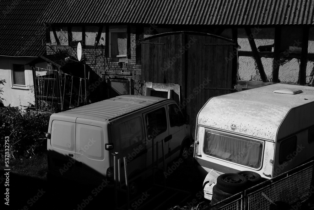 Alter Ford Transit und weißer Wohnwagen von Wilk vor einem alten ...