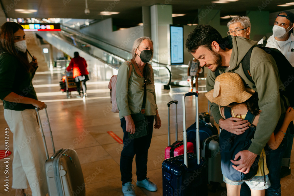 Multigenerational group of people hugging goodbye in airport terminal ...