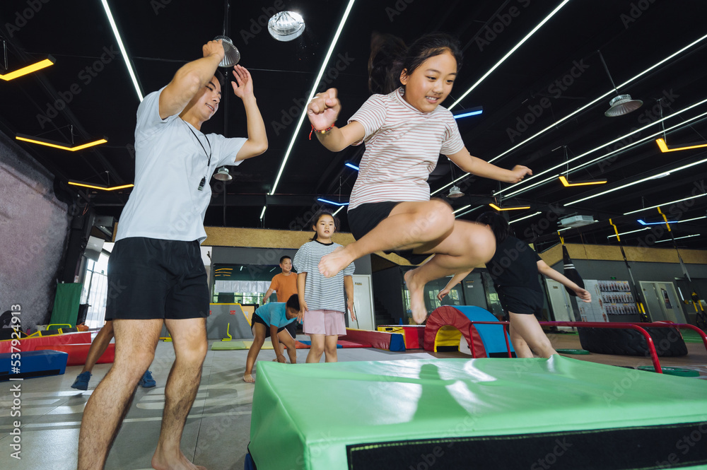 Asian coach instructing young kids Stock Photo | Adobe Stock