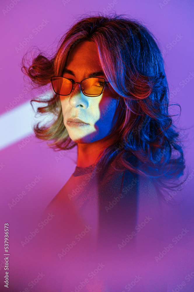 Transgender model under neon illumination Stock Photo | Adobe Stock