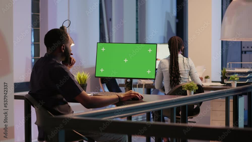Startup worker analyzing greenscreen on monitor in office with big ...