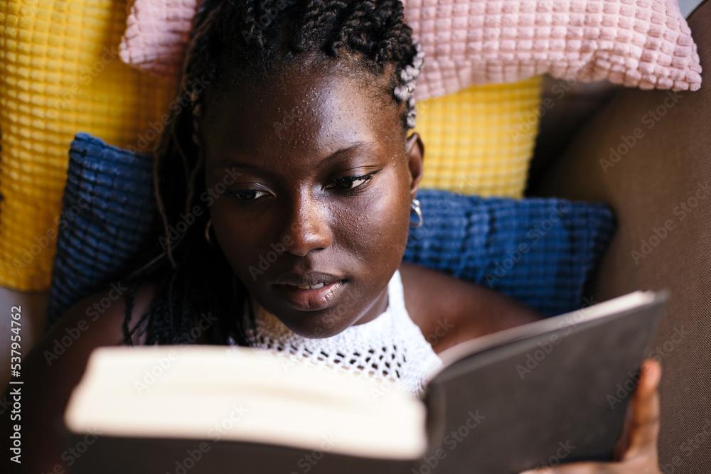 Black woman reading a book at home Stock Photo | Adobe Stock