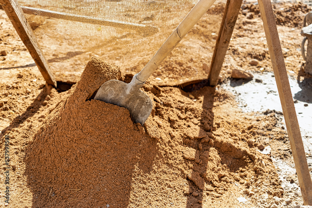 Sifting sand for mortar at the construction site. Purification of sand ...