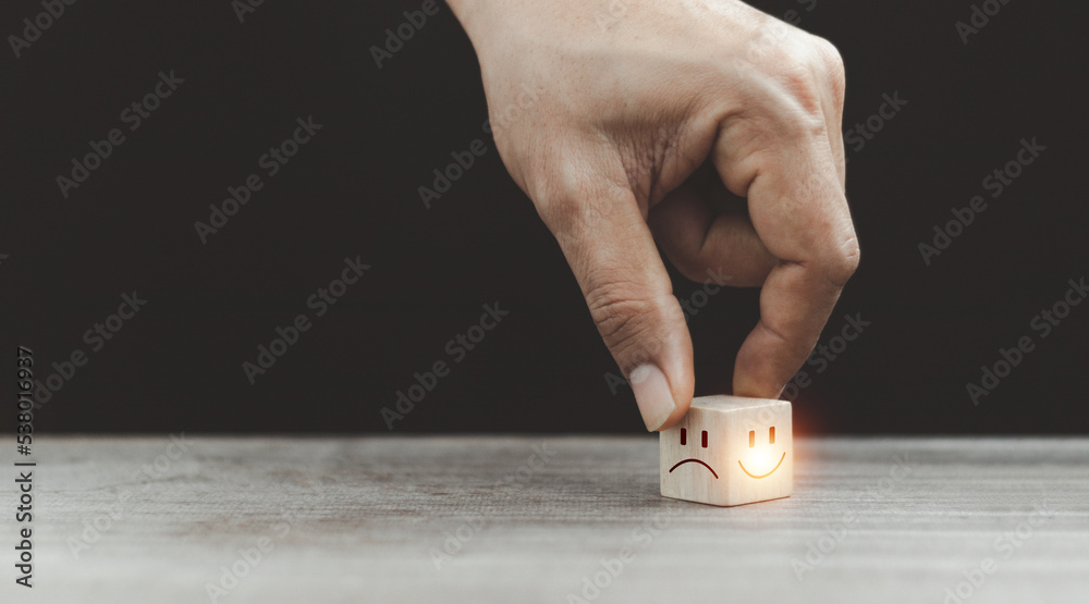 Close up customer hand choose smiley face and sad face icon on wood ...