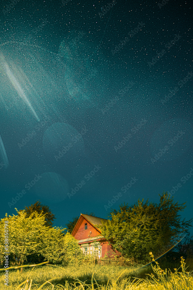 Night sky over house in village. Night starry sky above house with ...