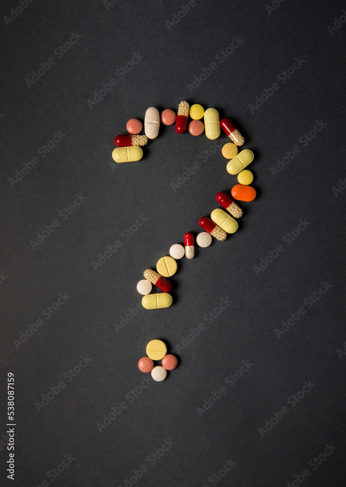 Question mark sign made with assorted drug capsules and tablets ...