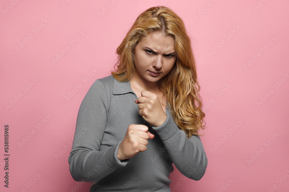 Angry young woman ready to fight on pink background Stock Photo | Adobe ...