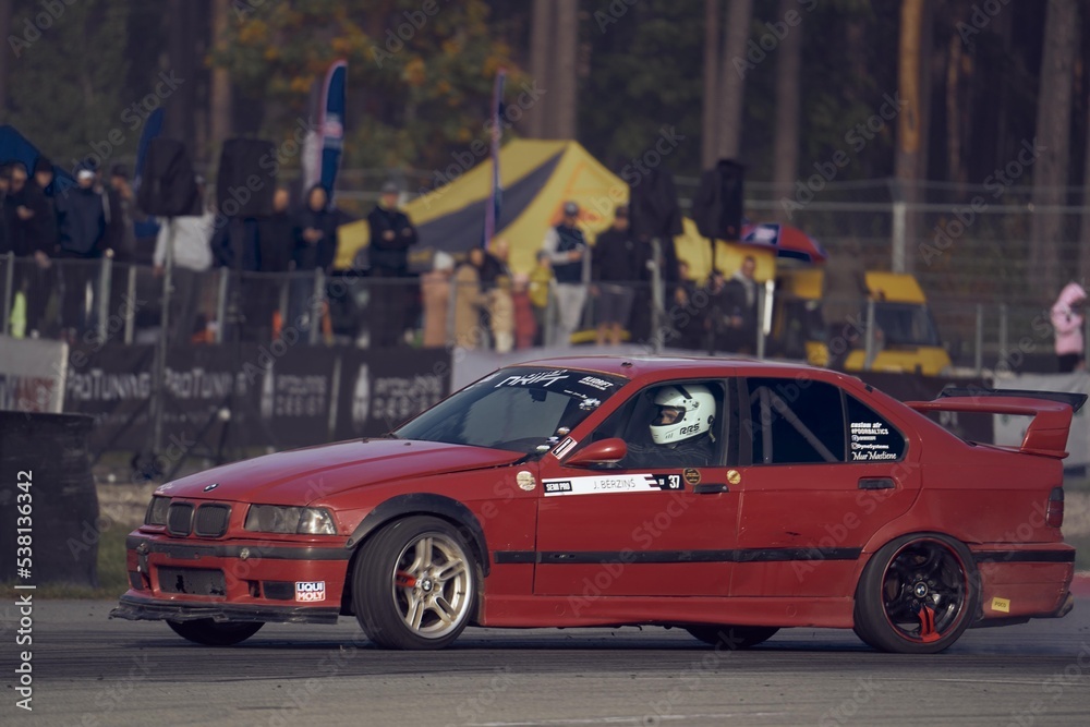 11-05-2022 Riga, Latvia a red car driving down a race track, a red race ...
