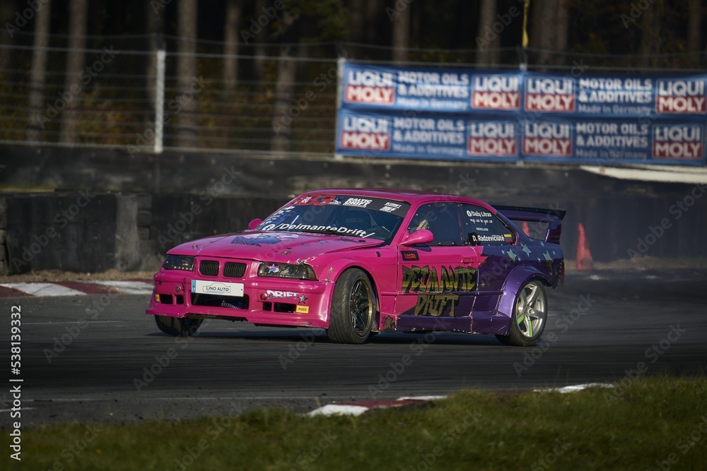 11-05-2022 Riga, Latvia a pink car is driving on a race track, a pink ...