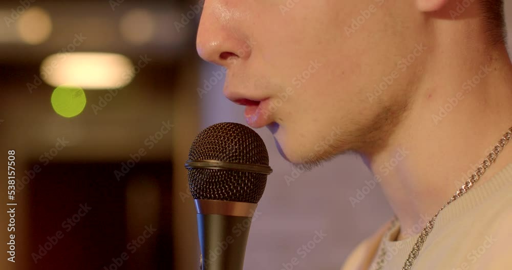 Close-up face element of a stand-up comedian with a microphone on stage ...