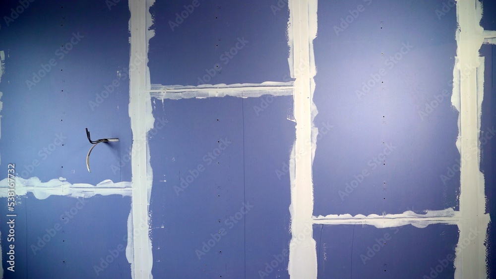 Installation or renovation of plasterboard partitions in a house. Blue ...