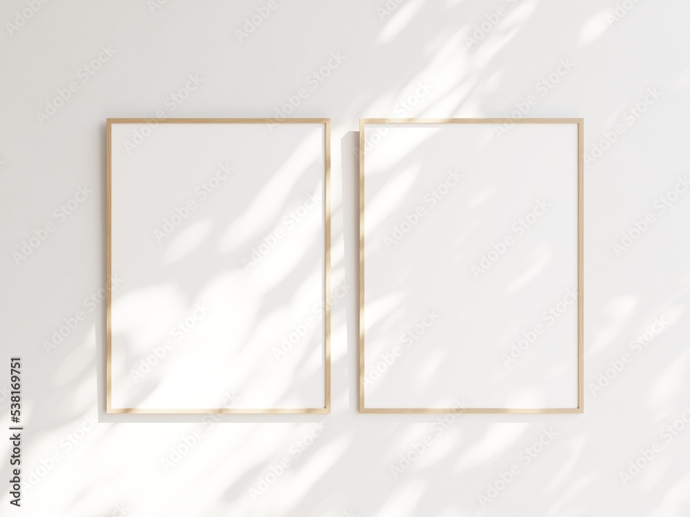 Pair of empty wooden picture frames hanging on white wall side by side ...