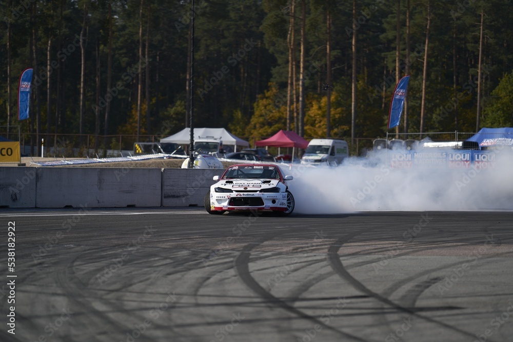 11-05-2022 Riga, Latvia a car is drifting on a track with smoke coming ...