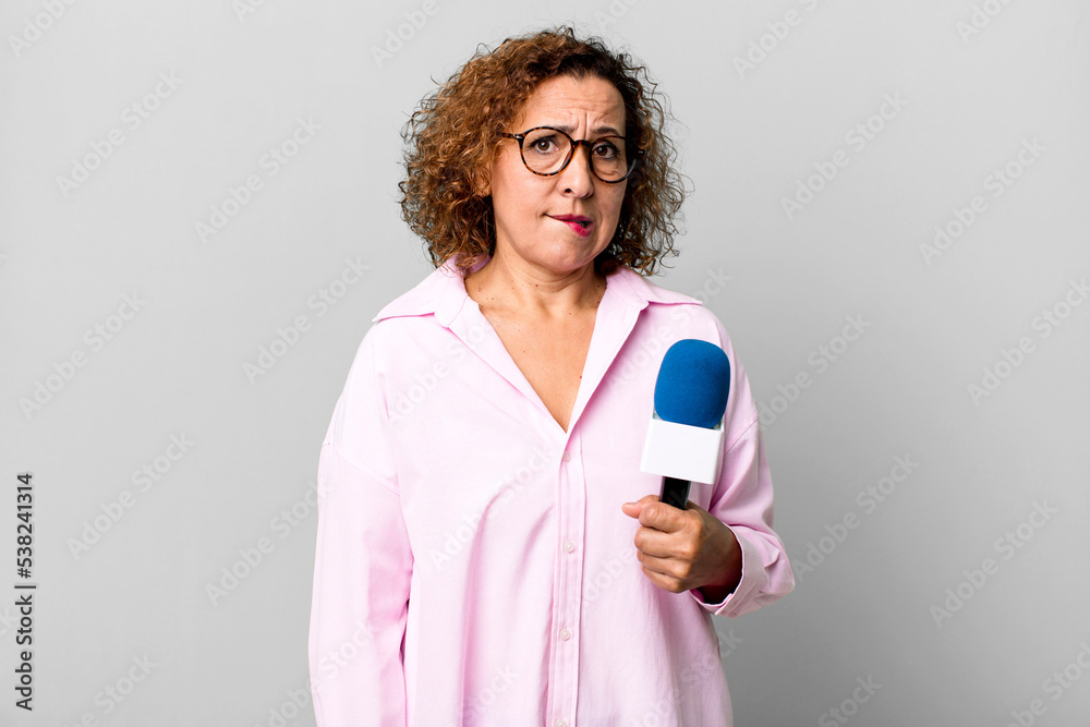 pretty middle age woman looking puzzled and confused. tv presenter with ...
