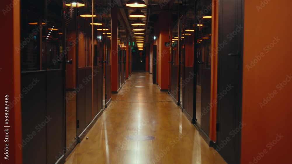 Fired upset man walking down in office hallway, holding box with books ...