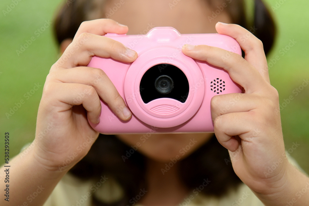 Girl taking a photo with her instant modern camera, natural green ...