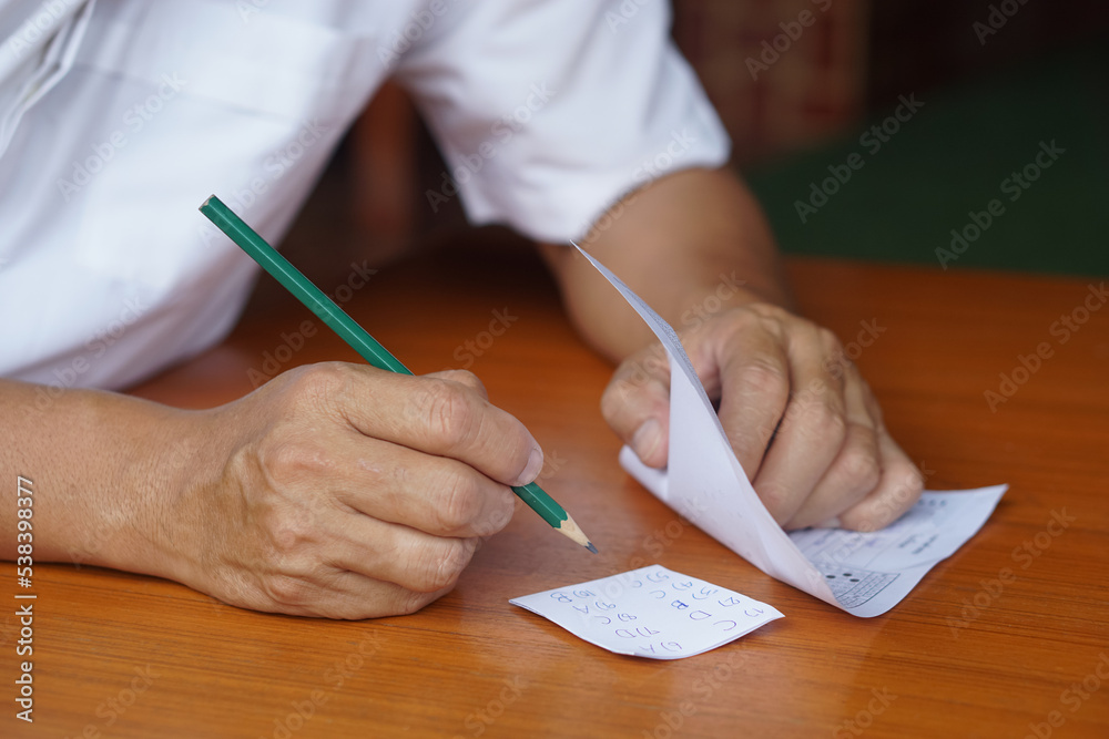 Foto de Closeup student is doing the test on paper answer and hide ...