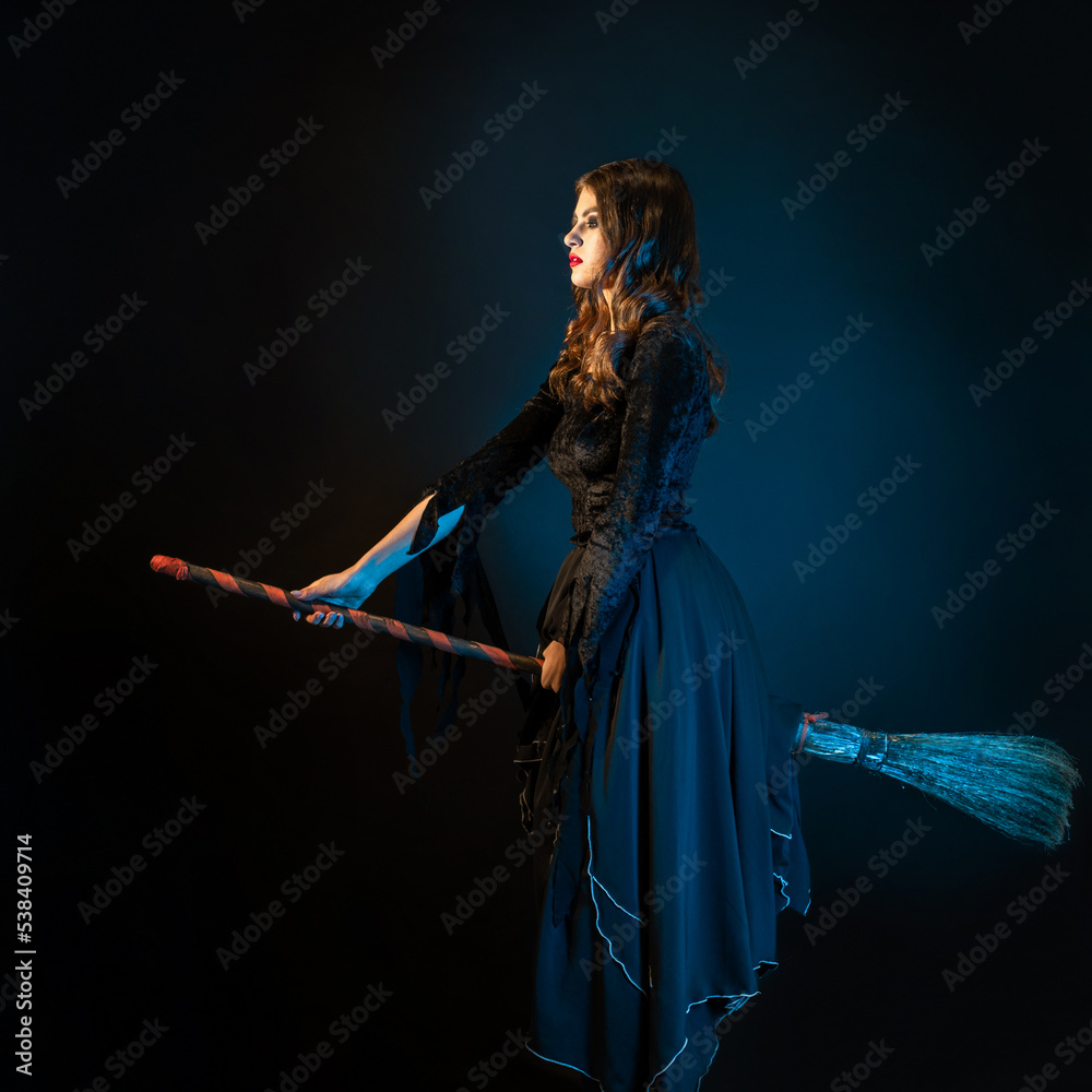 A beautiful witch on a broomstick is flying to the sabbath. Young ...