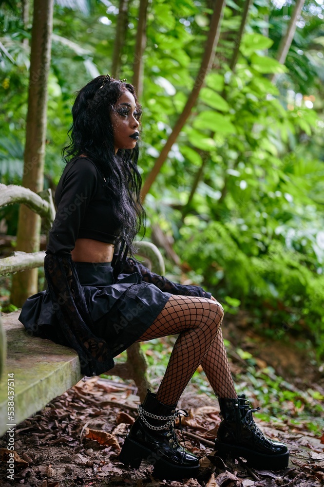 Vertical view of a Jamaican girl wearing gothic-style clothes and ...