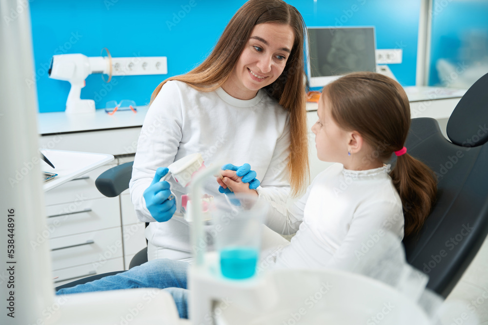 Child practicing tooth-brushing technique assisted by smiling ...