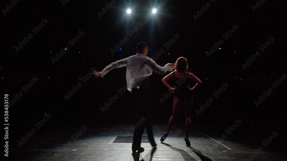 Ballroom dancers pair on concert hall stage,rear view.Slow motion ...