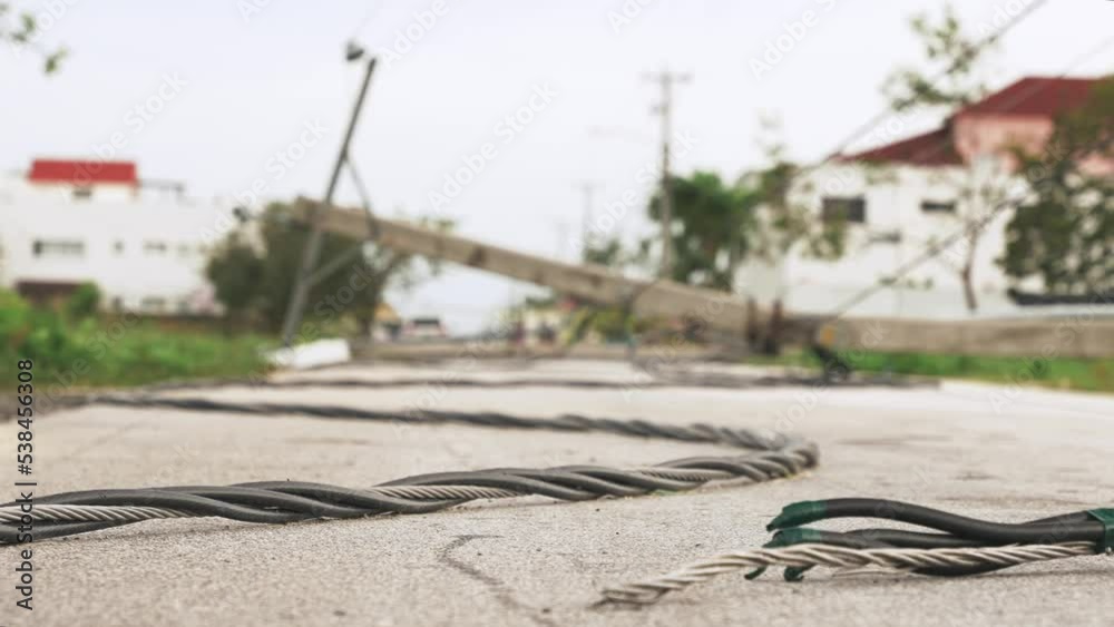 Fallen power line pole and cables after a tropical hurricane. Aftermath ...