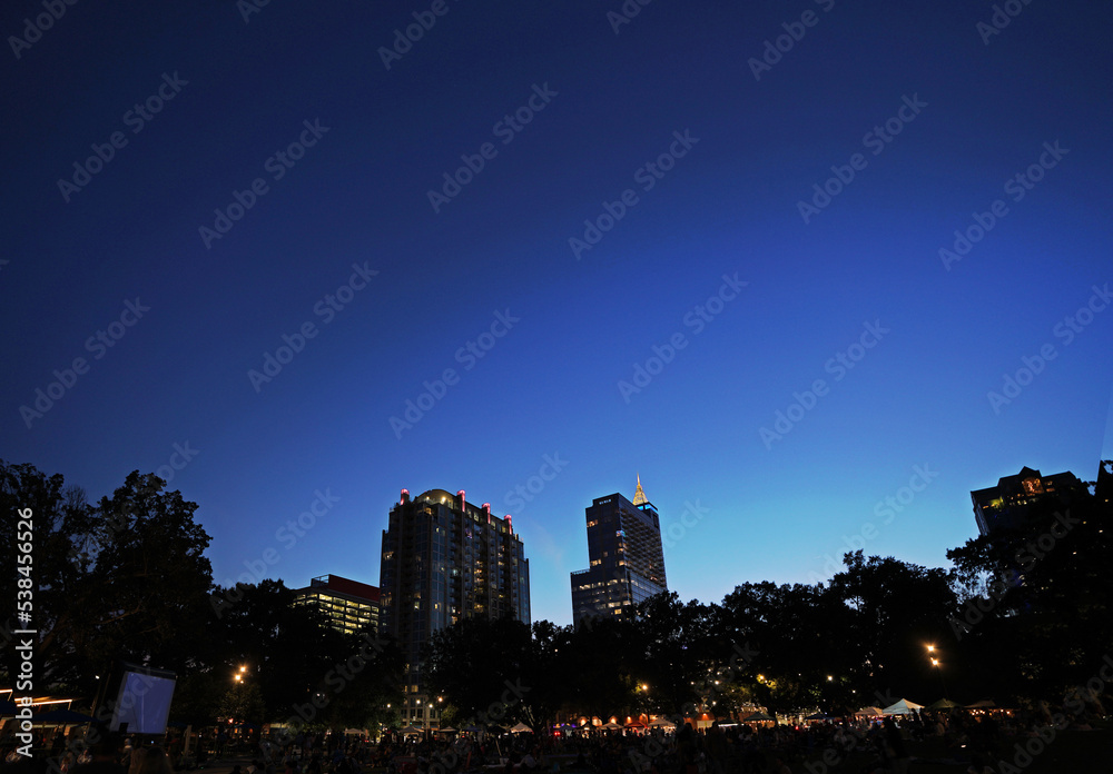 Movie night in Moore Square Park at dusk, with downtown Raleigh ...