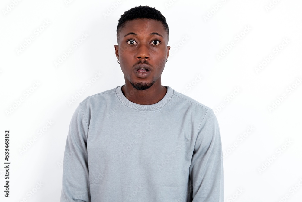 Shocked young handsome man wearing grey sweater over white background ...