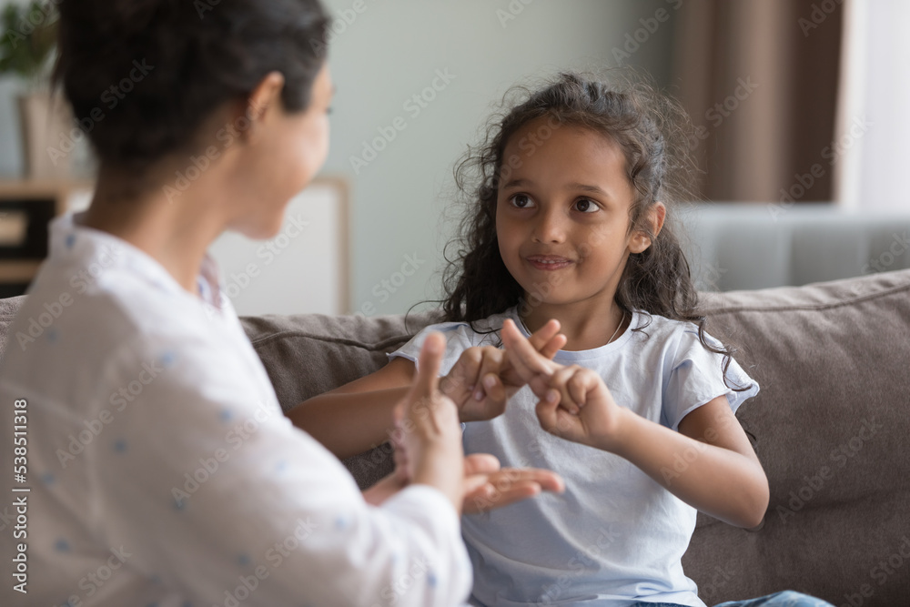 Deaf Indian preschooler girl and young mother showing symbols with ...