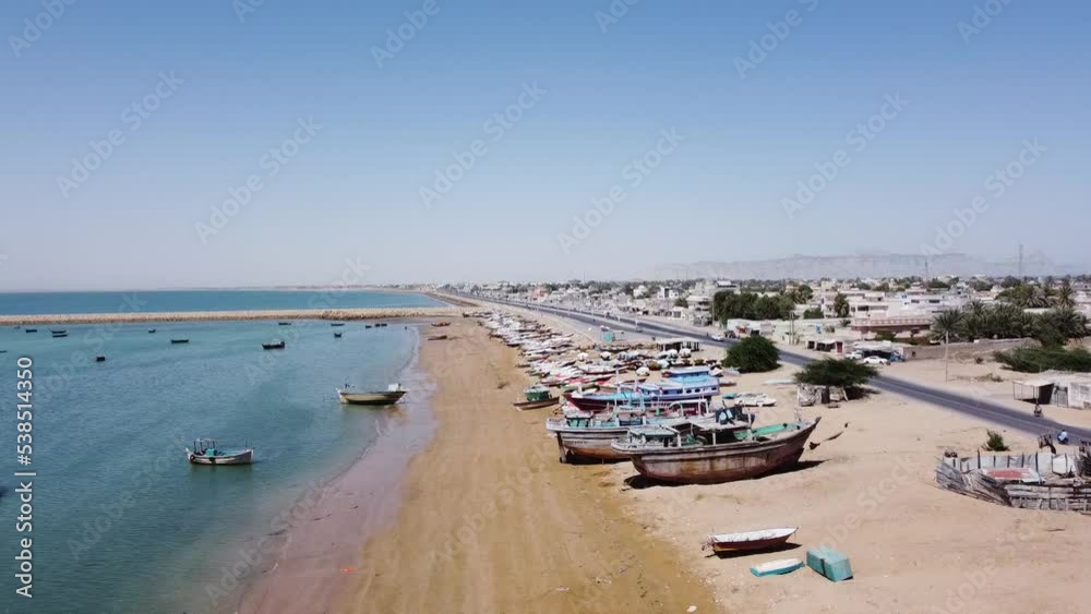 Aerial footage of the Arabian sea beach with lots of boats in the city ...
