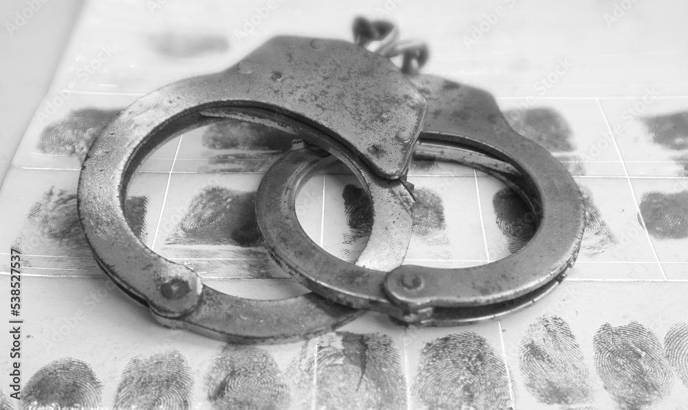 Crime and violence concept.Police Handcuffs on fingerprints crime page ...