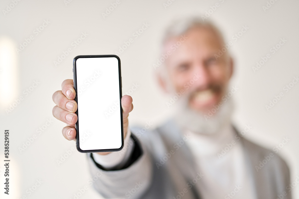 Business man wearing suit holding smartphone with white mock up screen ...