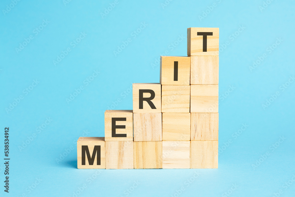 merit - text on a pyramid of wooden cubes, blue background Stock Photo ...
