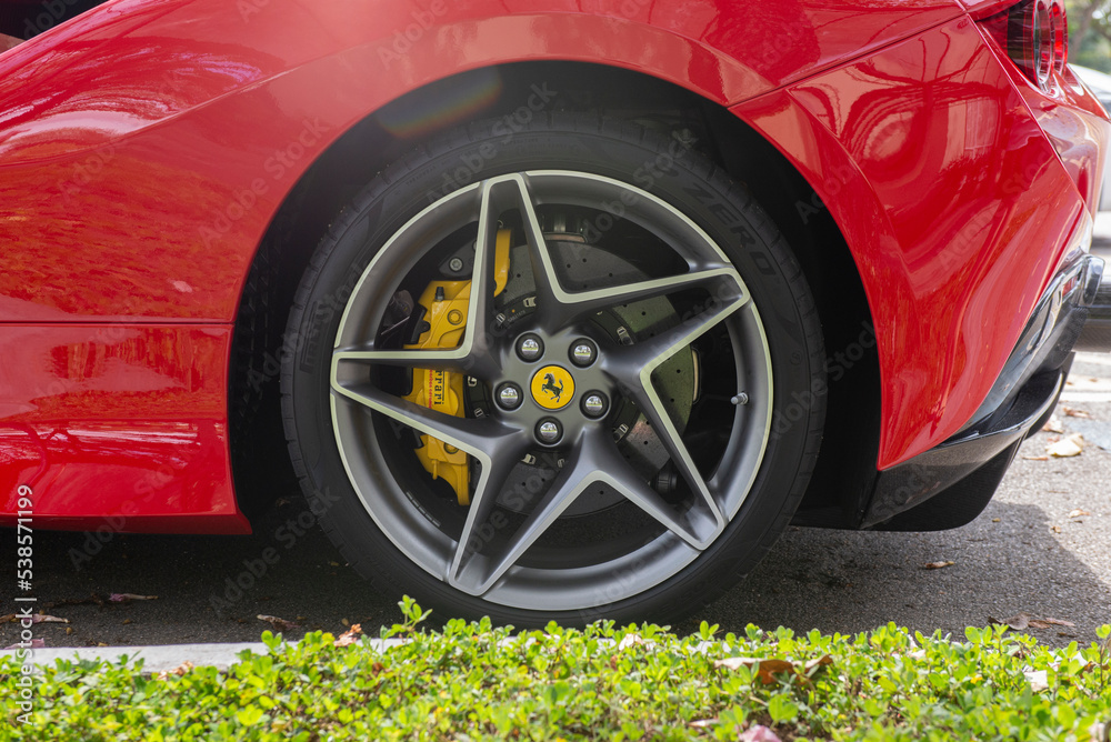 Side view of a wheel of a red Ferrari F8 Tributo parked on the street ...