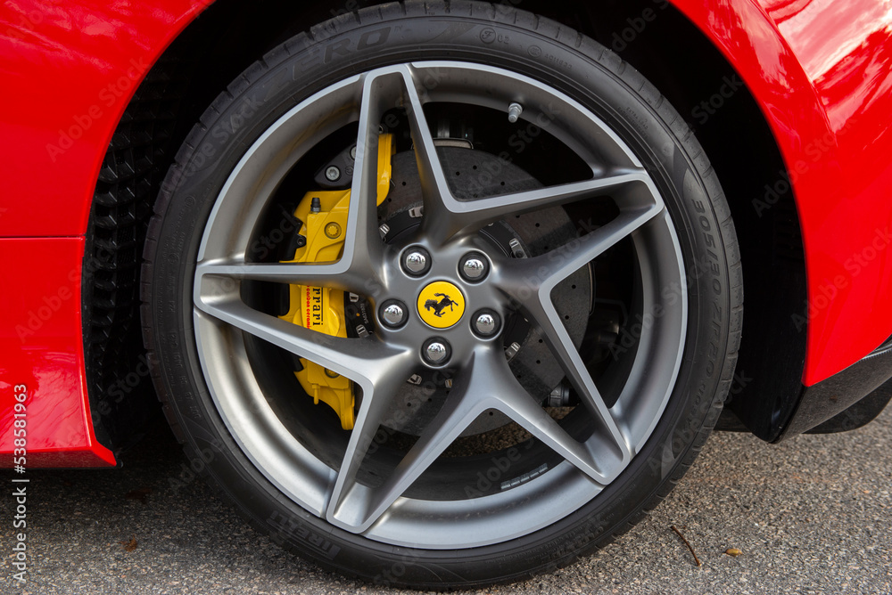 Side view of a wheel of a red Ferrari F8 Tributo parked on the street ...
