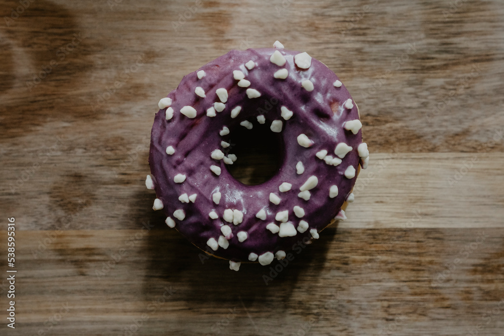 donuts color morado con azucar y chocolate encima de una tabla de ...