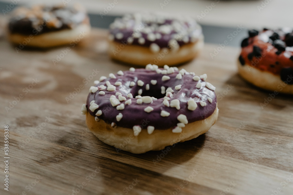 conjunto de donuts de diferentes colores con chocolate y azúcar encima ...