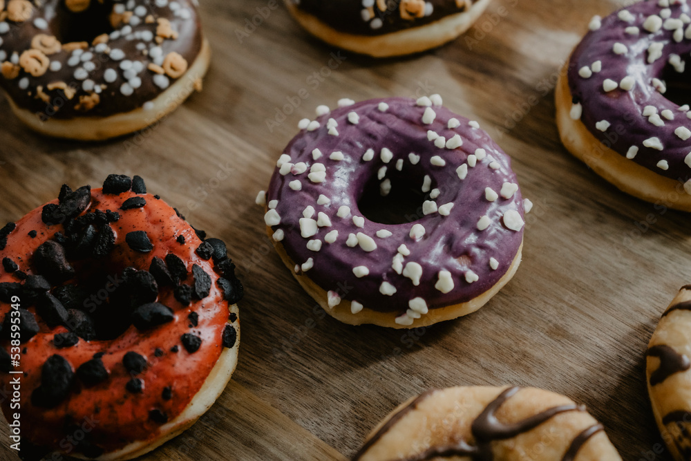 conjunto de donuts de diferentes colores con chocolate y azúcar encima ...