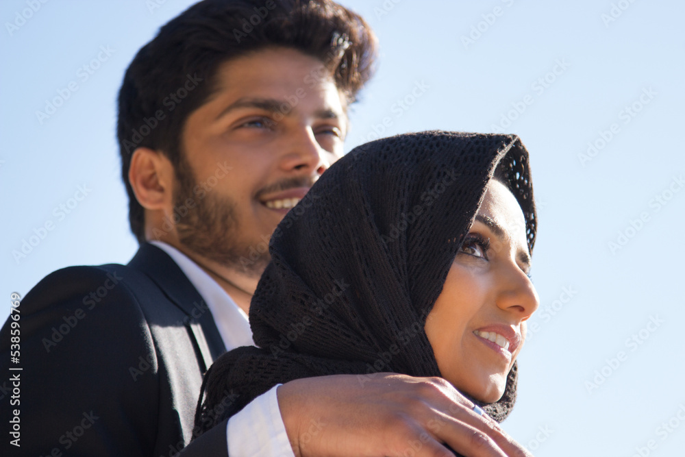 Side view of young romantic couple. Attractive Muslim woman in black ...
