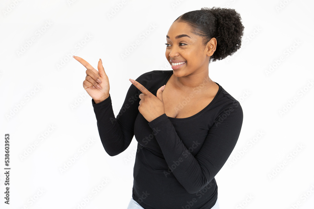Portrait of young woman pointing at something and sneering against ...