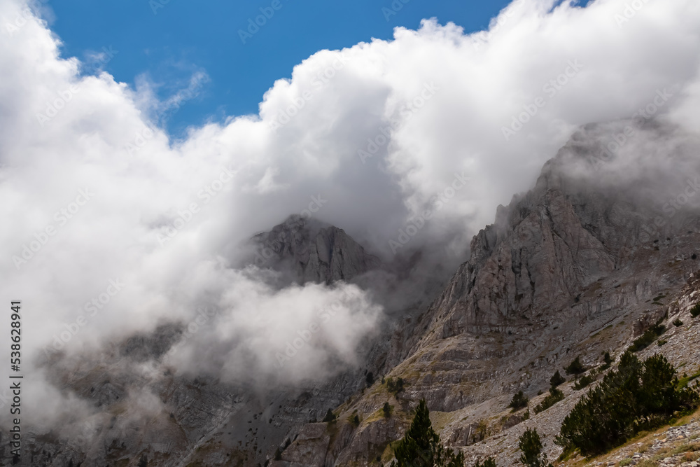 Panoramic view of the cloud covered slopes and rocky ridges of Pieria ...
