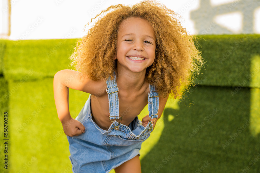 Playful little child girl portrait in the park, smiling and playing at ...