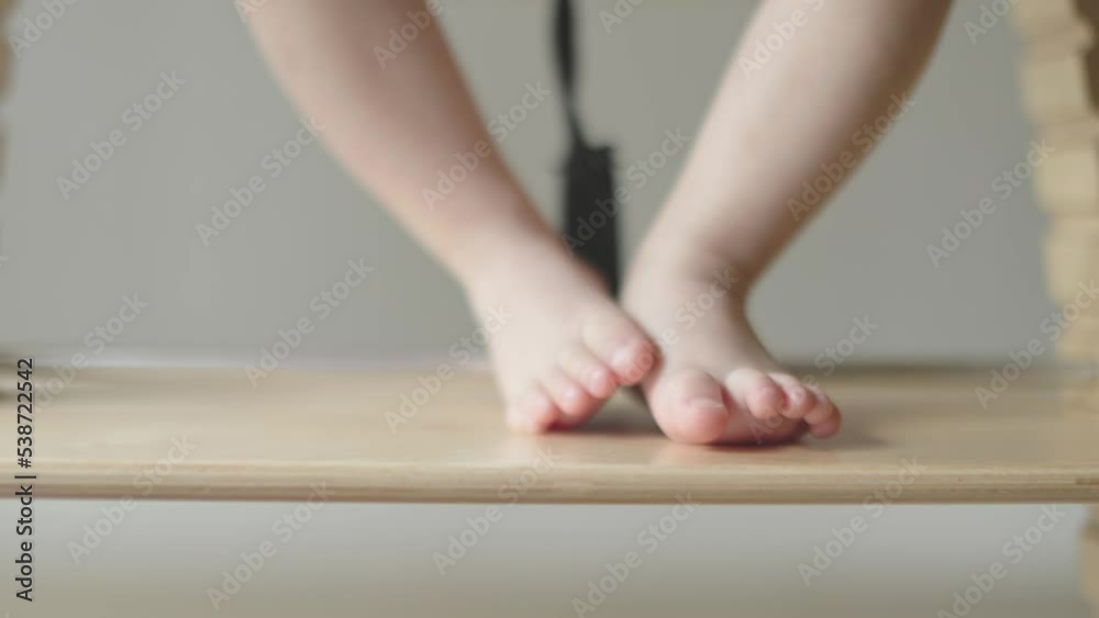 tiny barefoot baby feet of sitting child toes and heels moving on ...