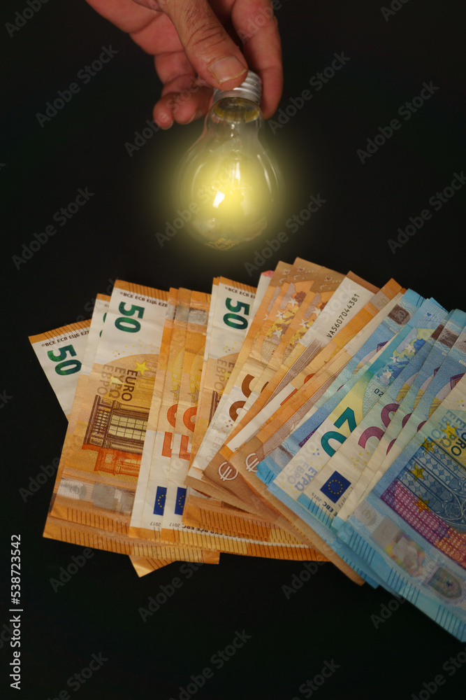 lighted light bulb with euro banknotes in the background Stock Photo ...