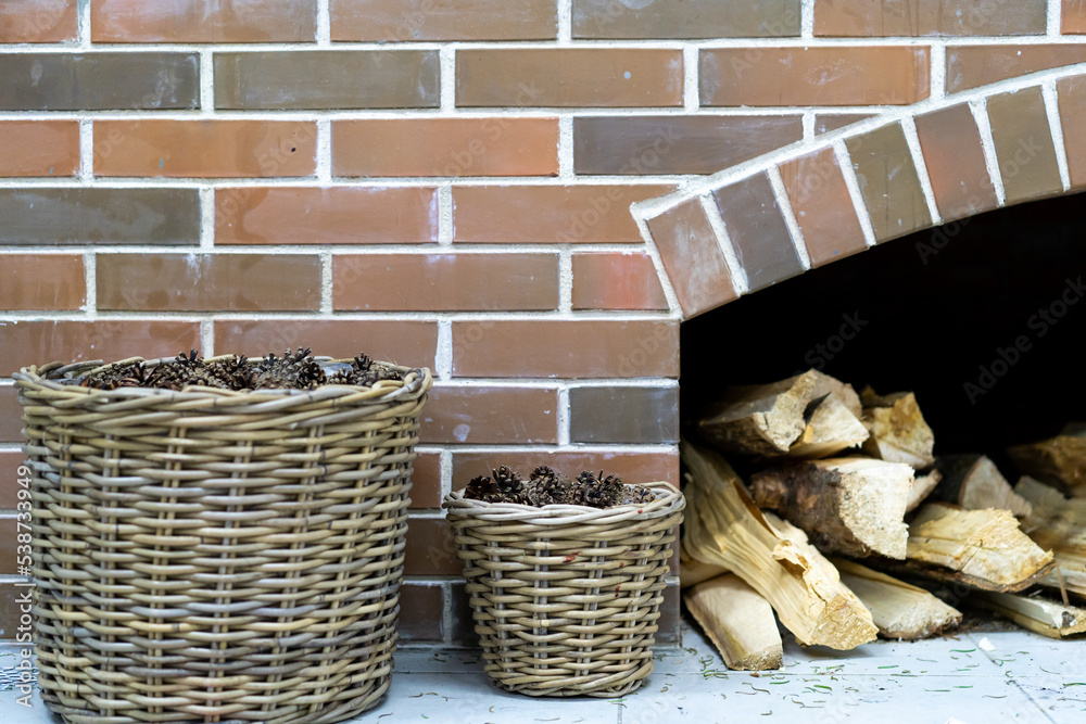 brick fireplace with wood and decorative baskets, the concept of ...