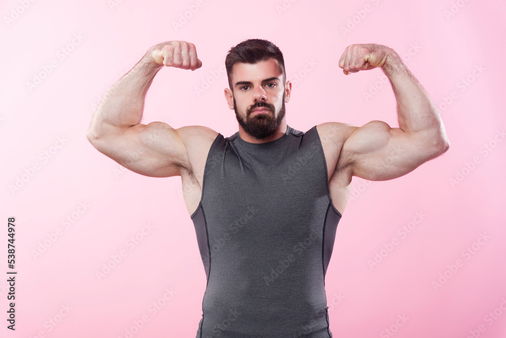 Strong man, a bodybuilder, flexing his biceps, showing off his big arms ...