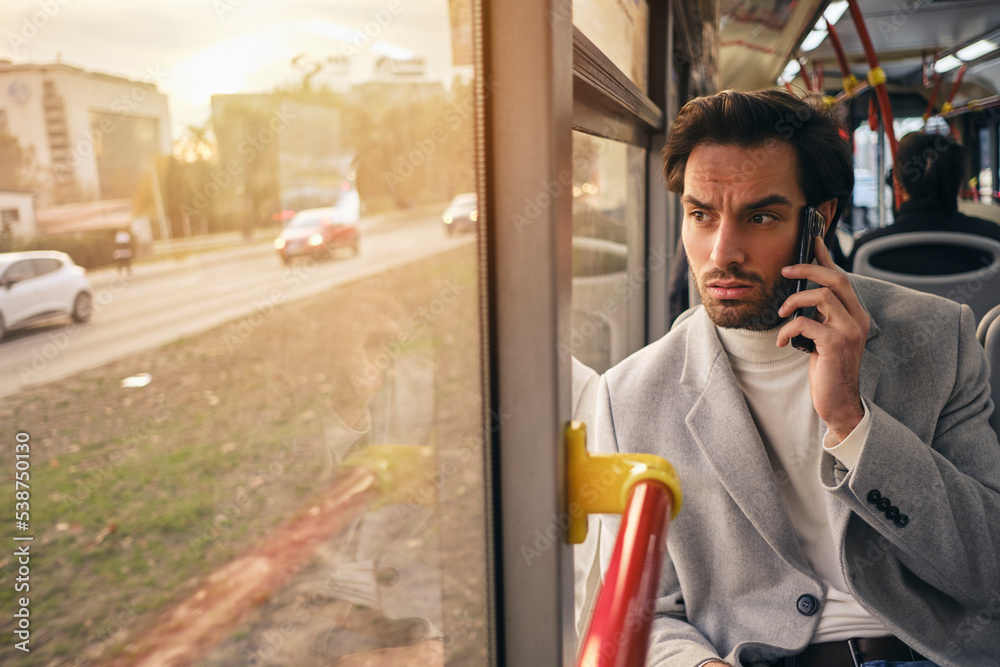 Young business man talking on a phone while commuting on a bus Stock ...