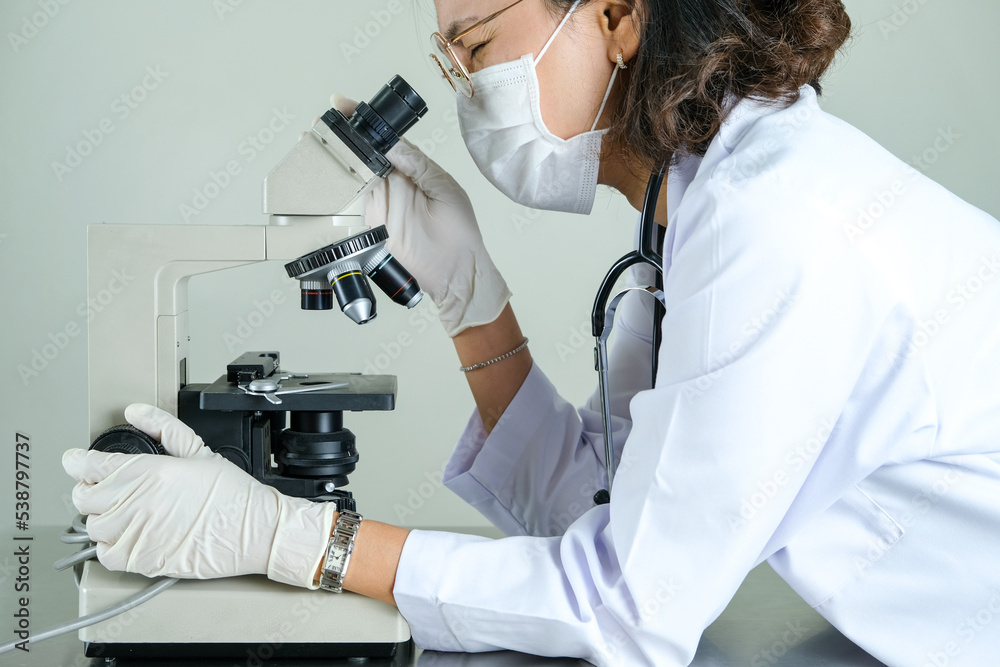 Cientist, she looks through the camera to see the details and ...